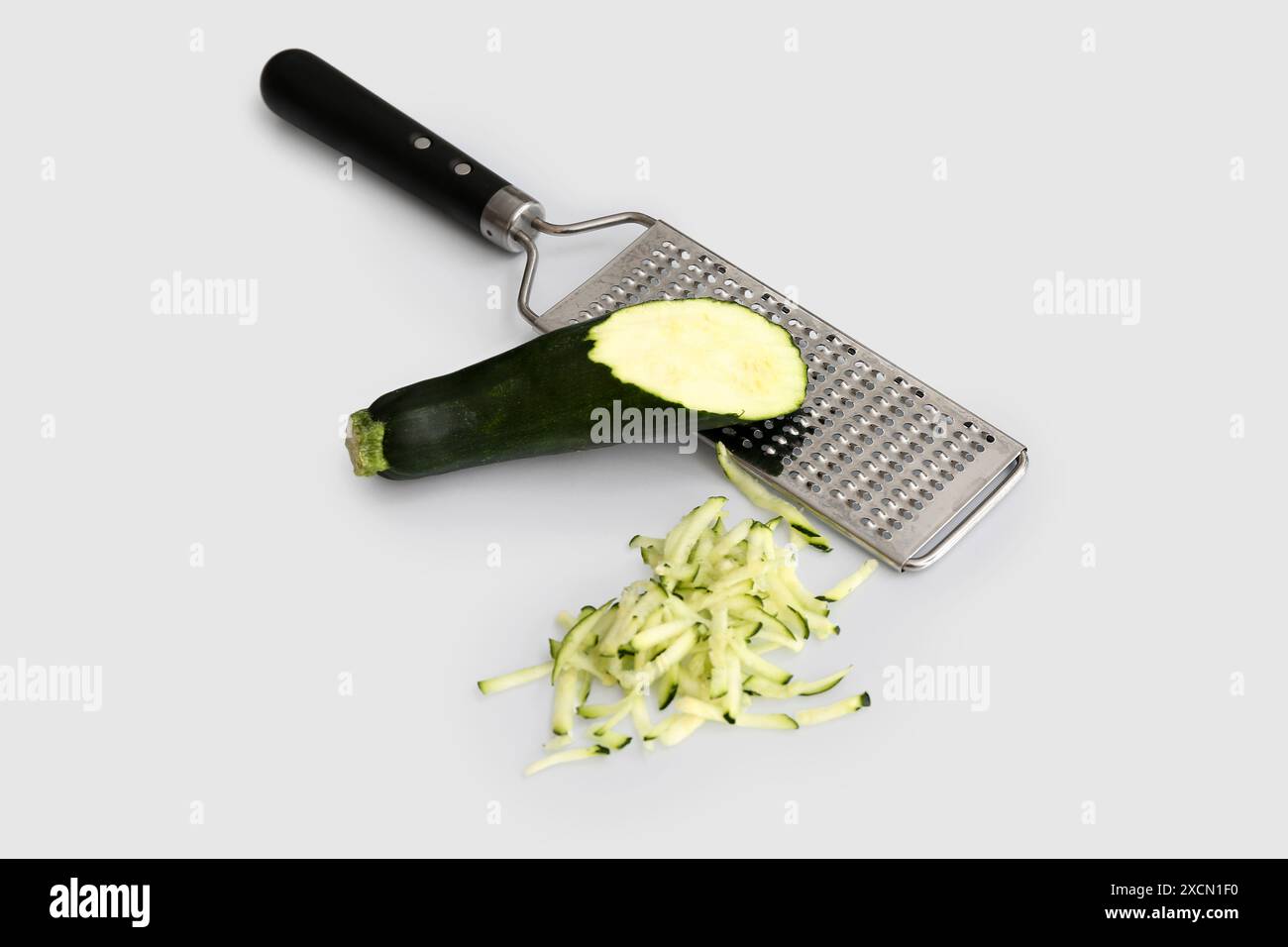 Fresh green zucchini and grater on white background Stock Photo - Alamy