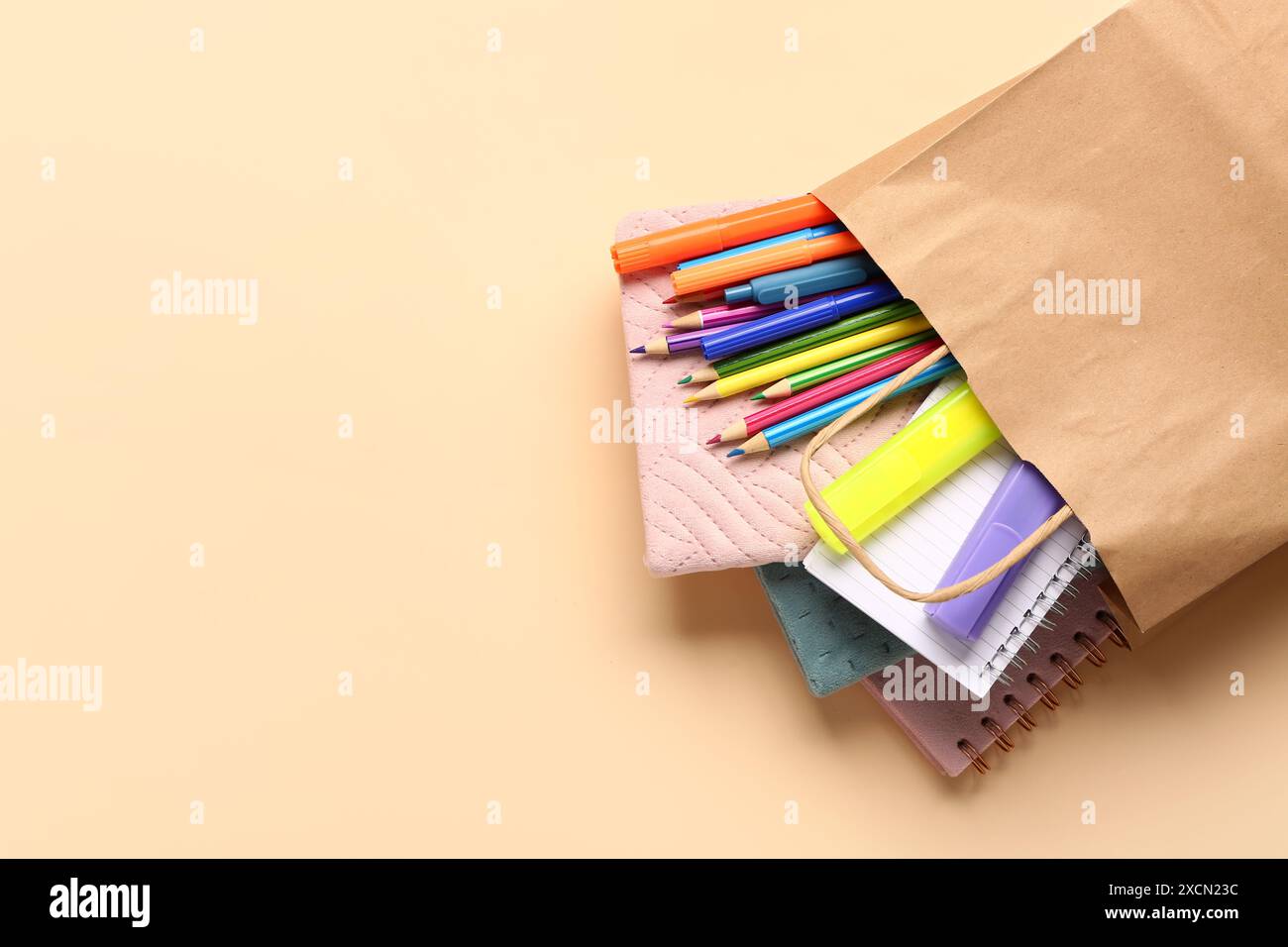 Shopping bag with different school stationery on beige background Stock ...