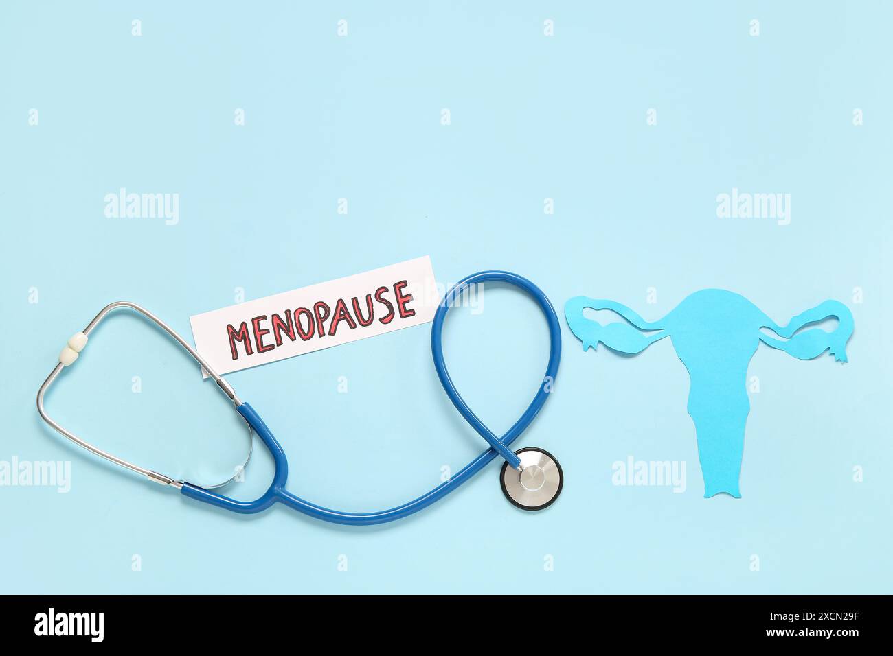 Word MENOPAUSE with paper uterus and stethoscope on blue background ...