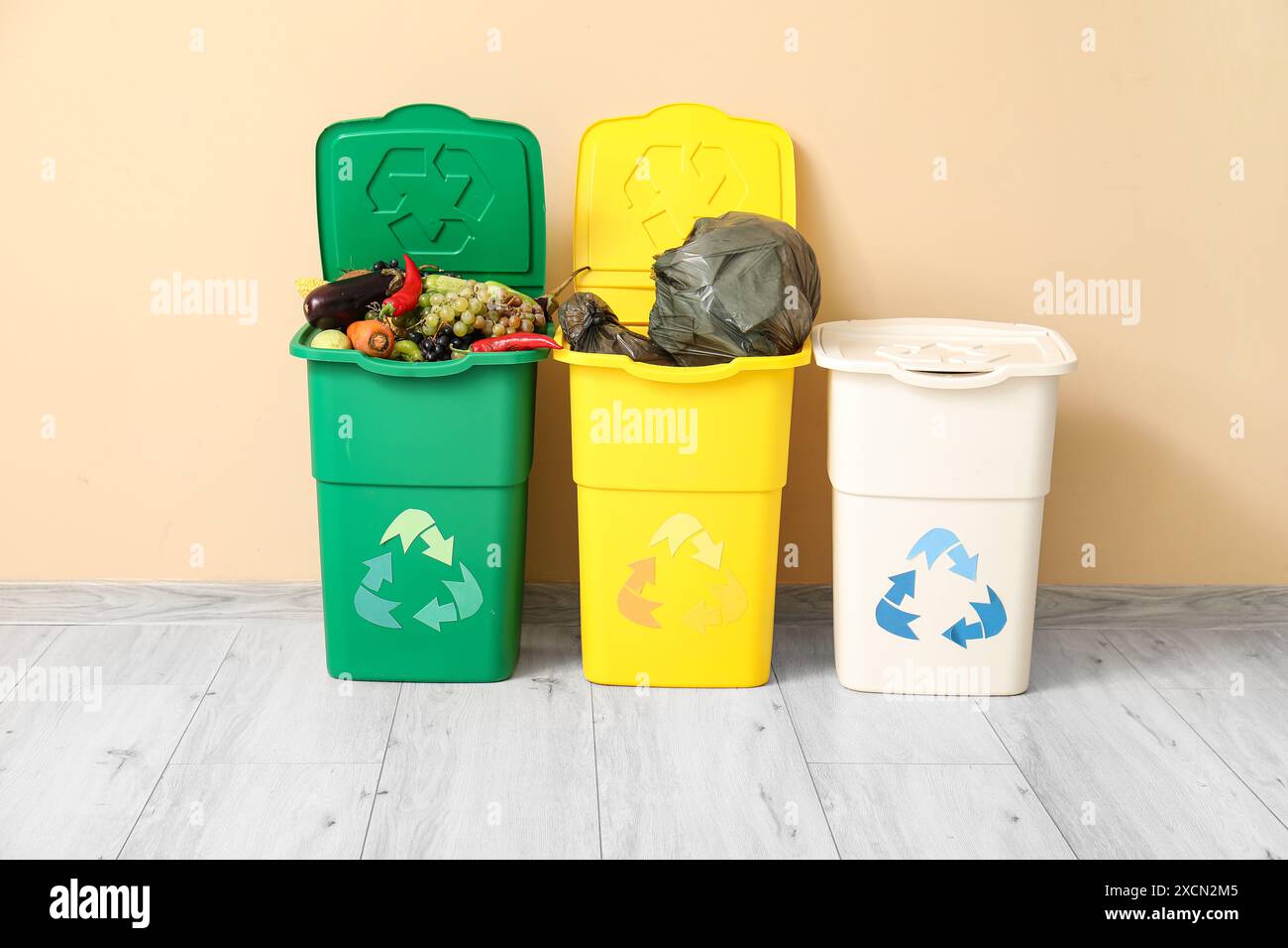 Containers for trash with food waste and full garbage bag near beige ...