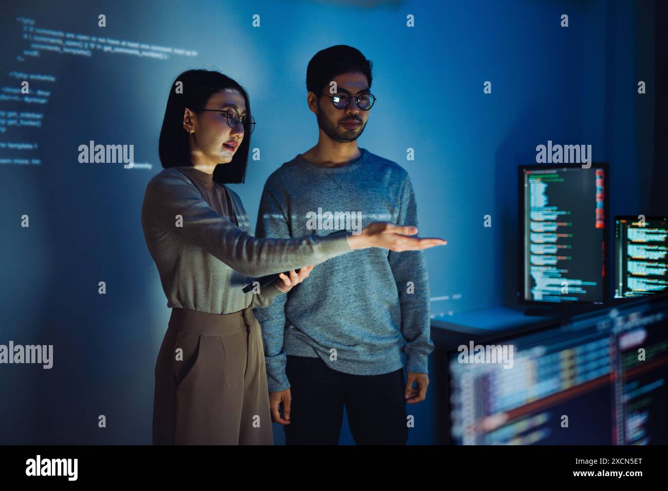 Asian Two Software Developers Engaged In Collaborative Coding Session With Code Projected Onto