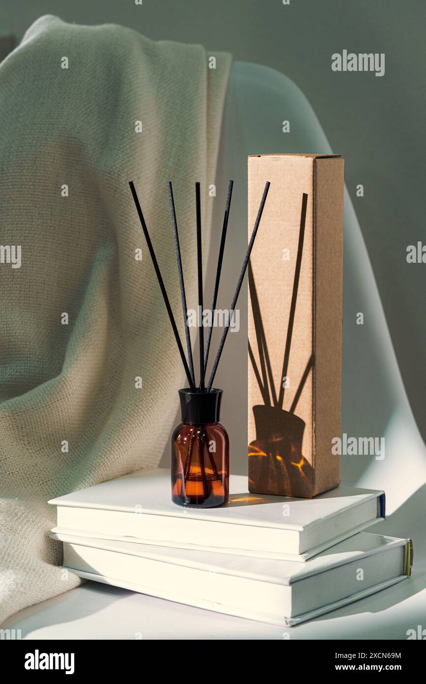 Liquid home perfume in glass diffuser with sticks on chair Stock Photo ...