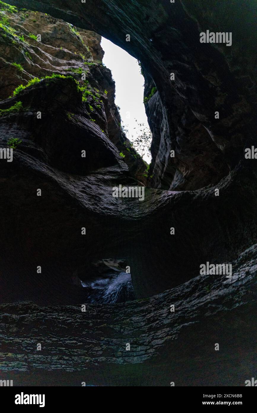 A cave with a small opening in the middle Stock Photo - Alamy