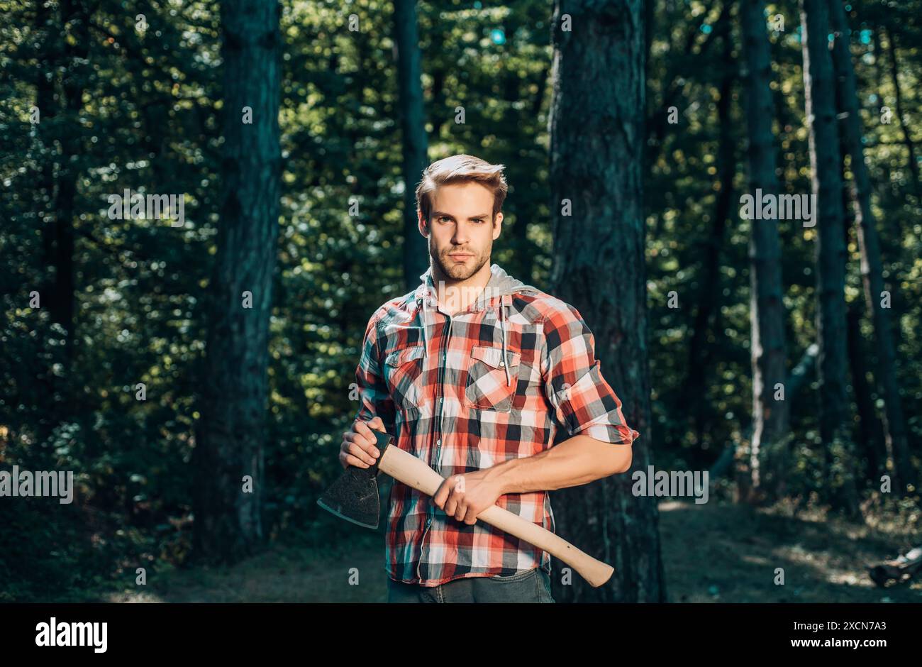 A handsome young man with a beard carries a tree. Stylish young man ...
