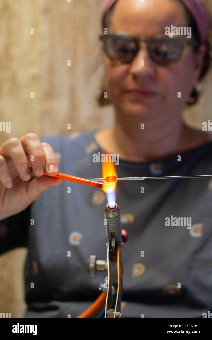 Artisan creating a glass jewel in her workshop Stock Photo - Alamy