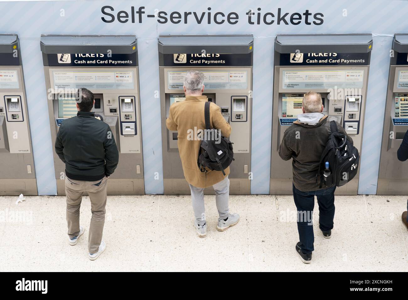 File photo dated 03/03/23 of people using a ticket machine at Waterloo ...