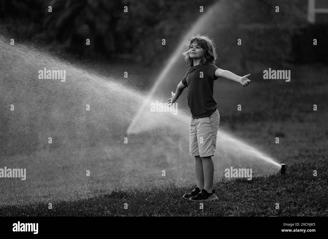 Child playing at summer backyard. Water fun in garden. Kid play with ...