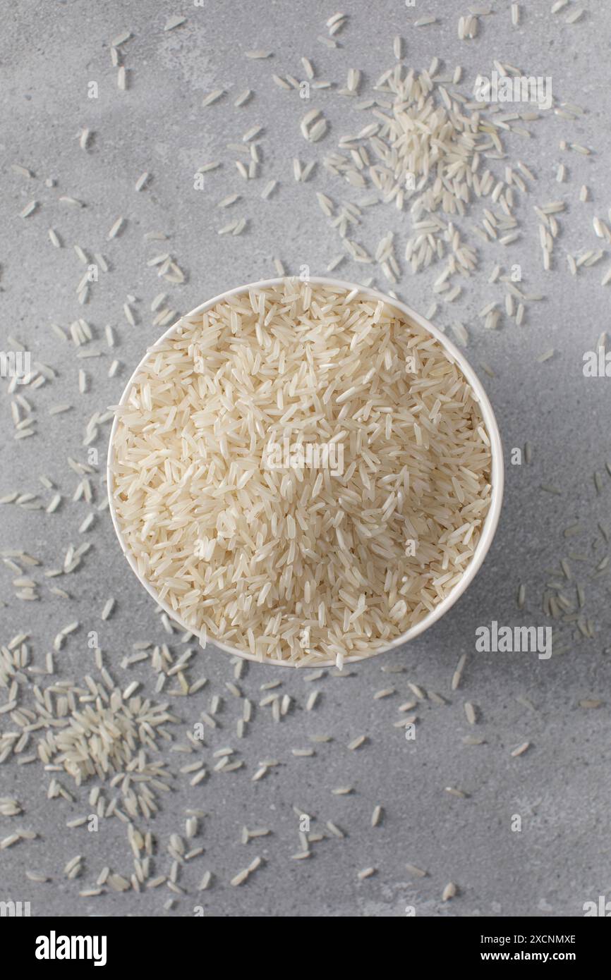 Basmati rice bowl and scattered grains on light grey background Stock ...