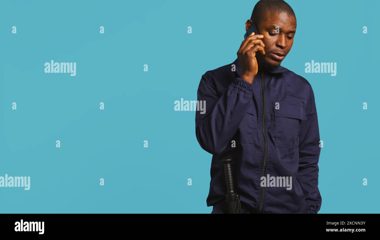 Security guard using cellphone to make call to friends during ...
