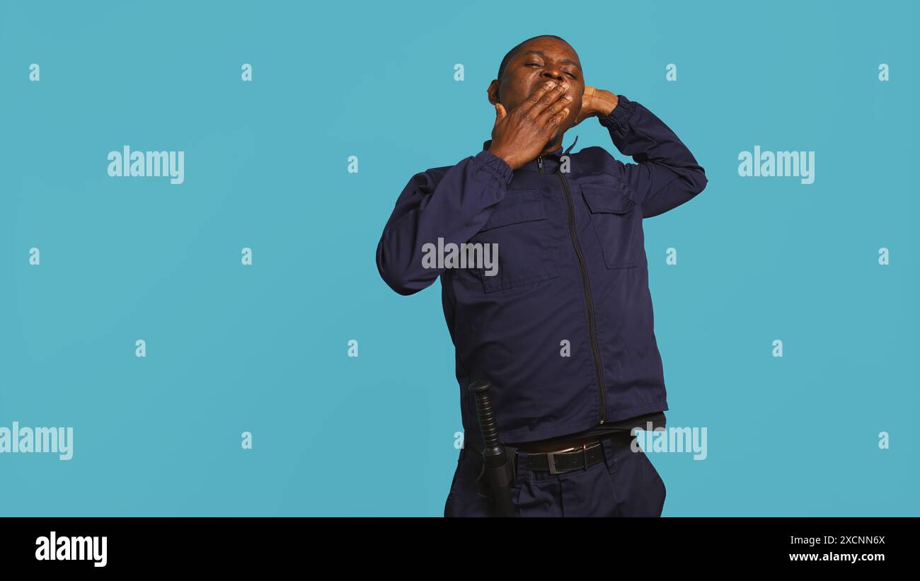 Tired security guard yawning while being tasked with preventing ...