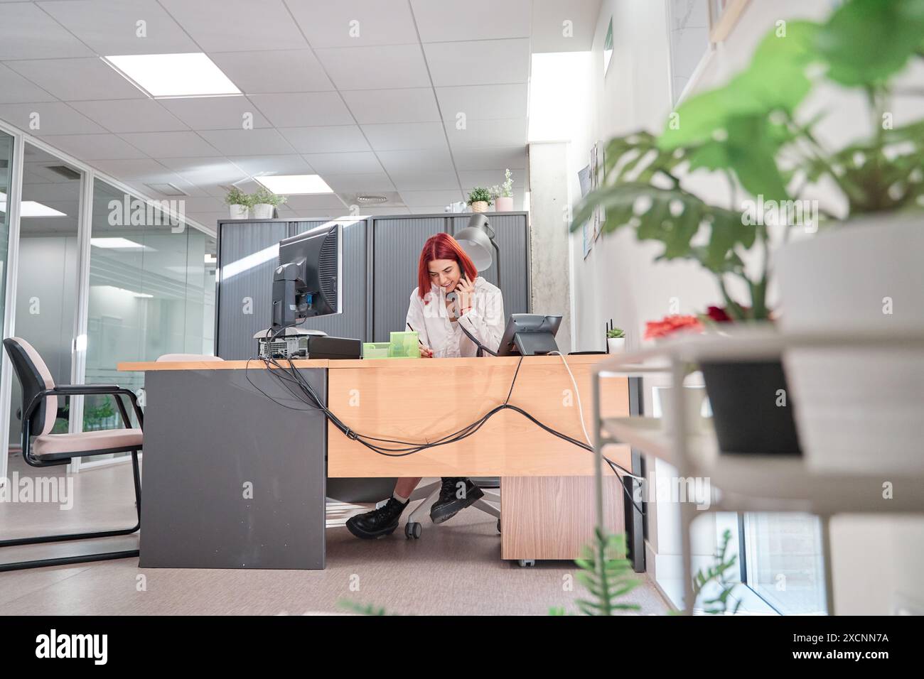 full view of a secretary talking on the phone at the office reception ...