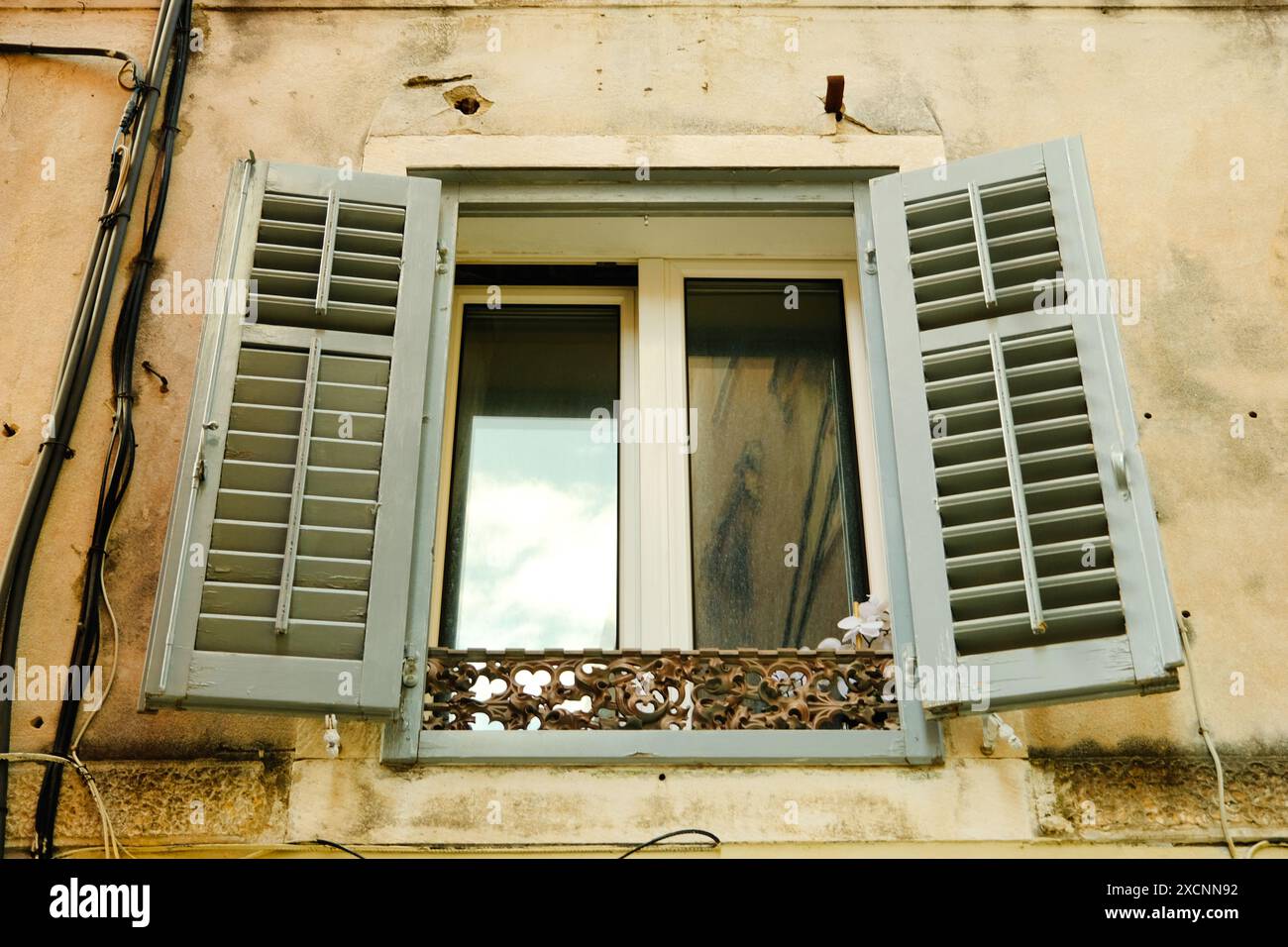 . An old style wooden window, it is open and you see the clouds ...