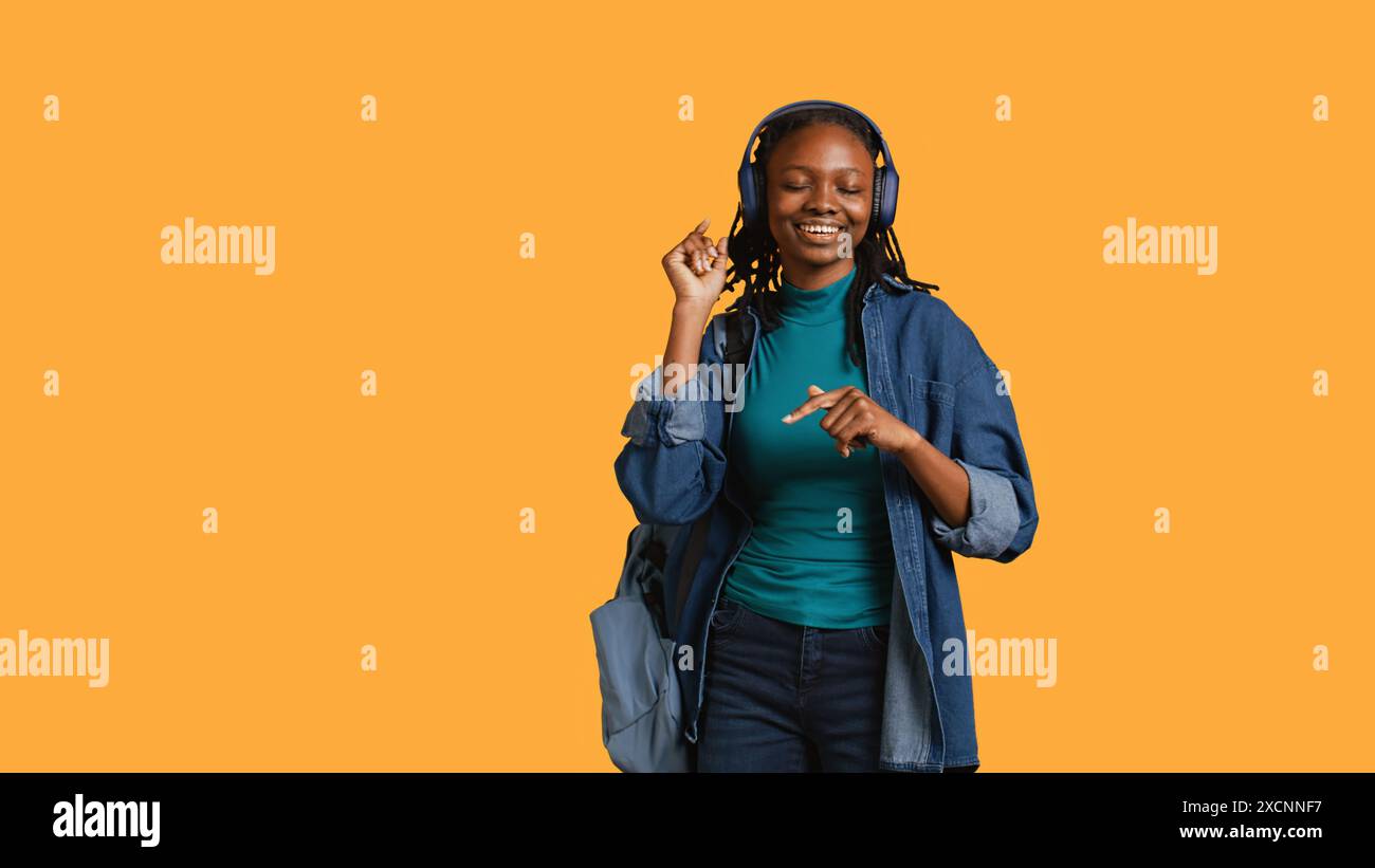 Joyous african american woman doing happy dance, listening music ...