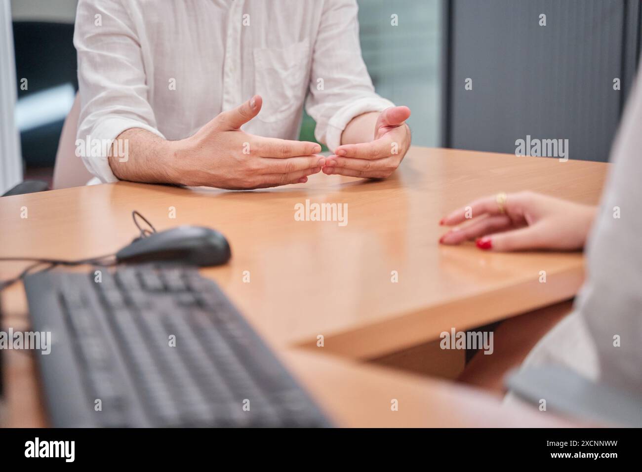 unrecognizable woman attending to a man in a clinic or at a reception ...