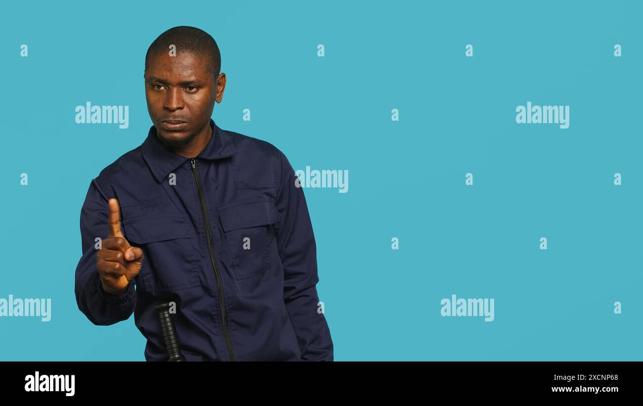 Security guard doing no gesturing with finger, prohibiting public ...