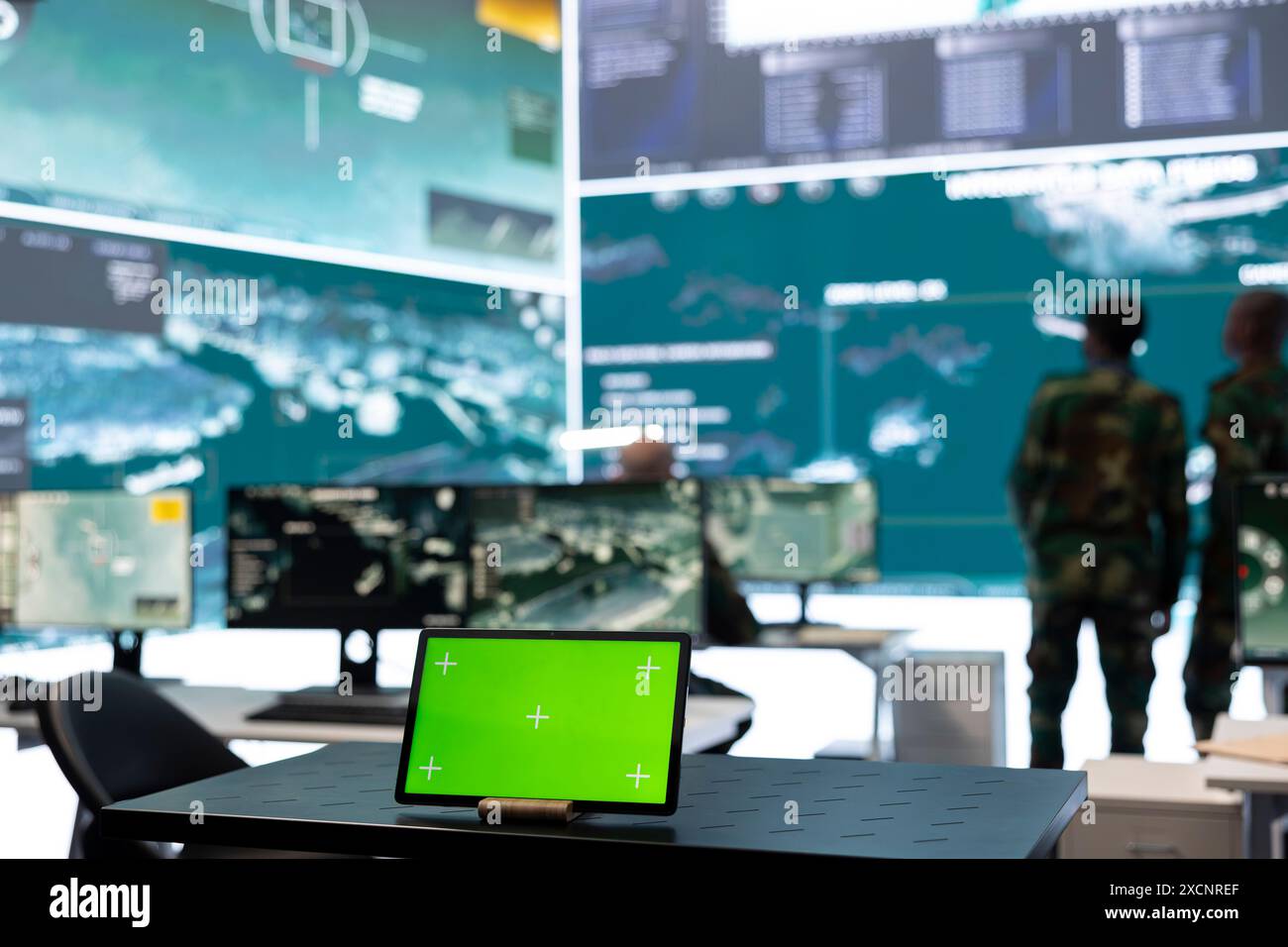 Laptop showing isolated chroma key screen in army monitoring room, military staff working on ...