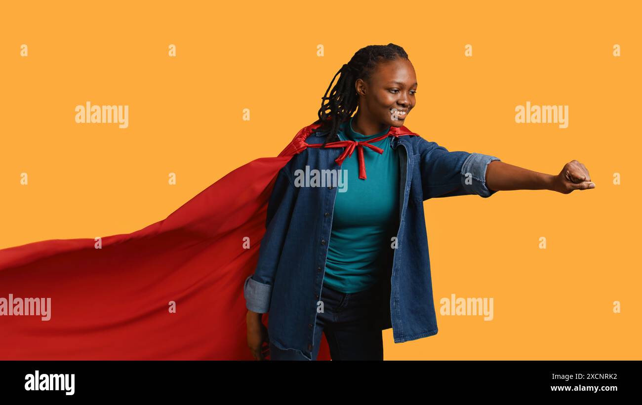 Happy girl portraying superhero flying with cape fluttering in wind ...