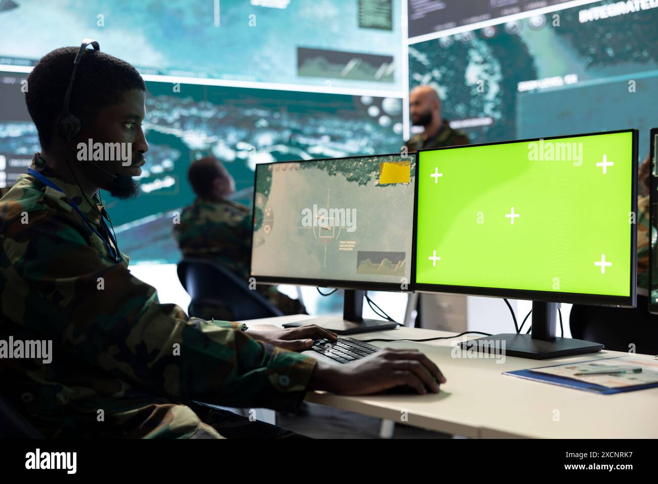 Trooper working on reconnaissance operation with green screen, using military satellite imagery ...