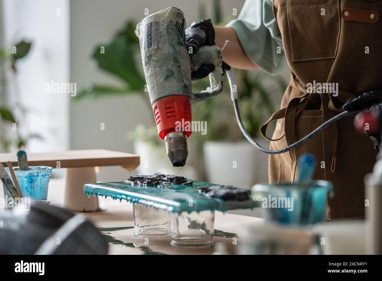 Professional woman hands working with epoxy resin to create ...