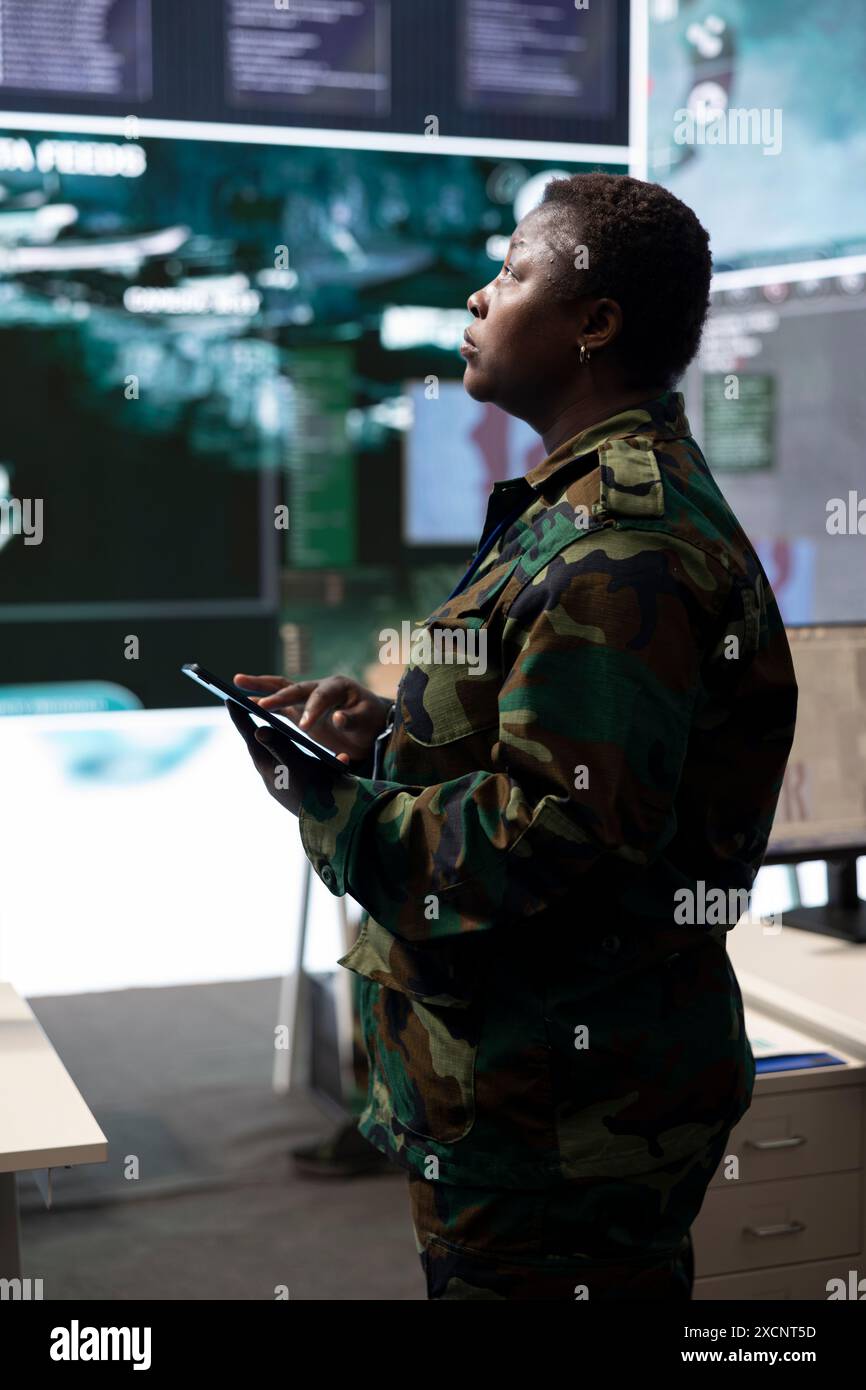 Woman trooper analyzing crucial battlefield data on a big screen in ...