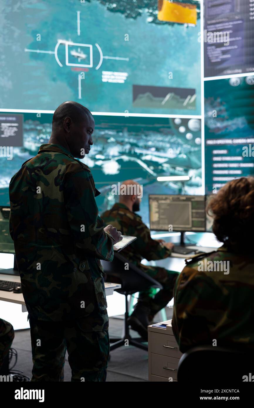 Special operations engineer examining surveillance CCTV footage to ...