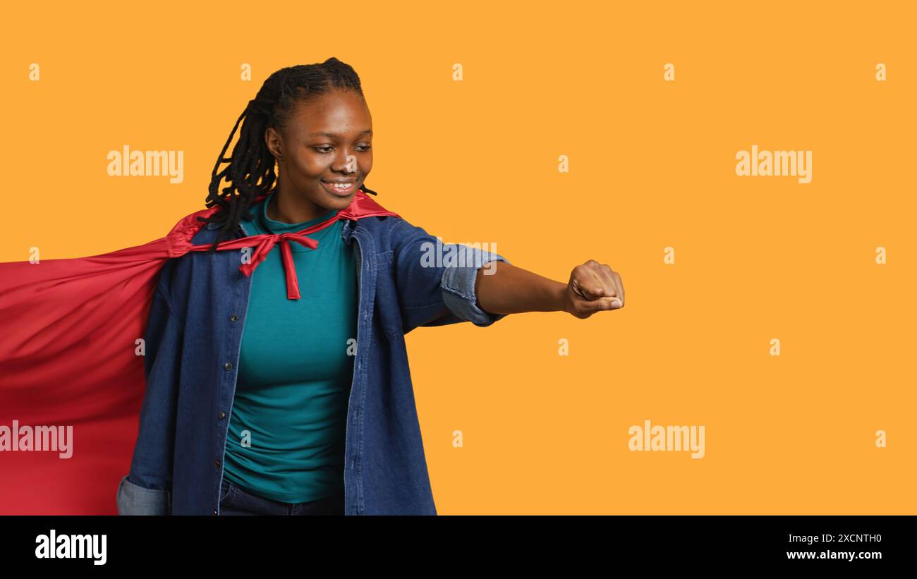 Happy girl portraying superhero flying with cape fluttering in wind ...