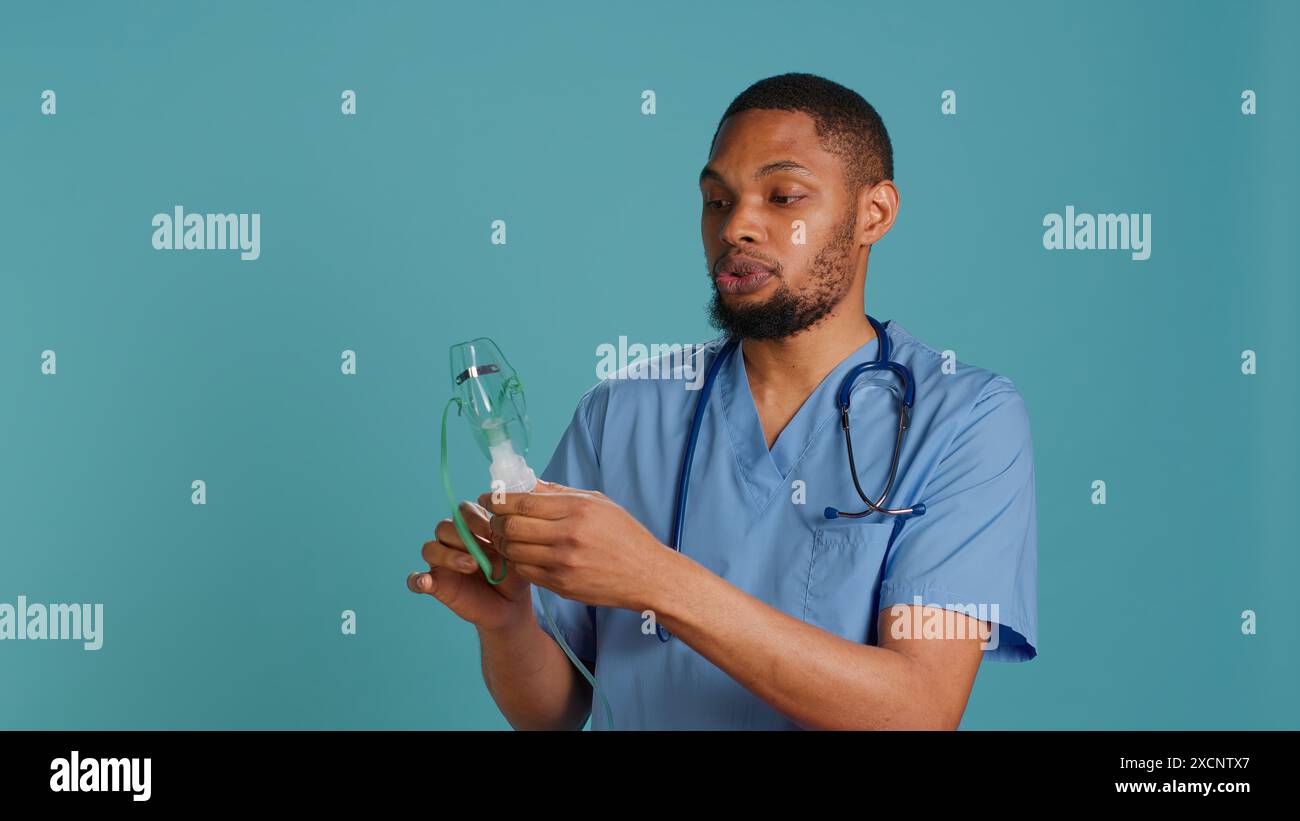 Male nurse holding handheld nebulizer used for delivering aerosols ...