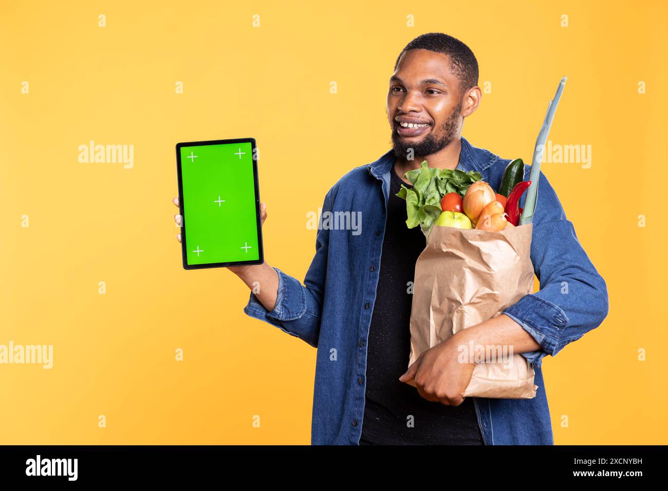 Satisfied african american guy presenting greenscreen display on a ...