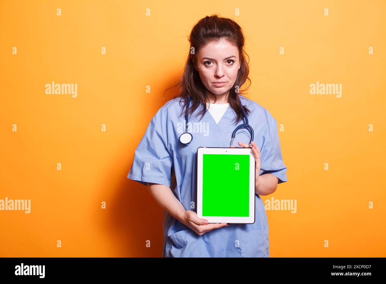 Healthcare professional vertically holding tablet with green screen ...