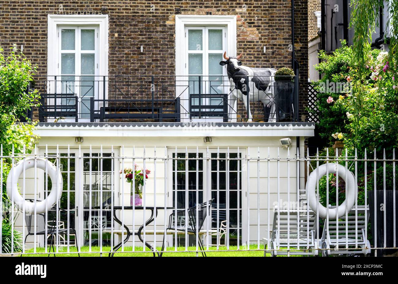 London, UK. A cow (possibly not real) on a balcony by the Regents Canal ...