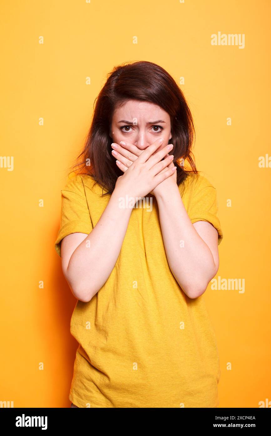 Portrait of brunette lady covering her mouth with both hands in ...