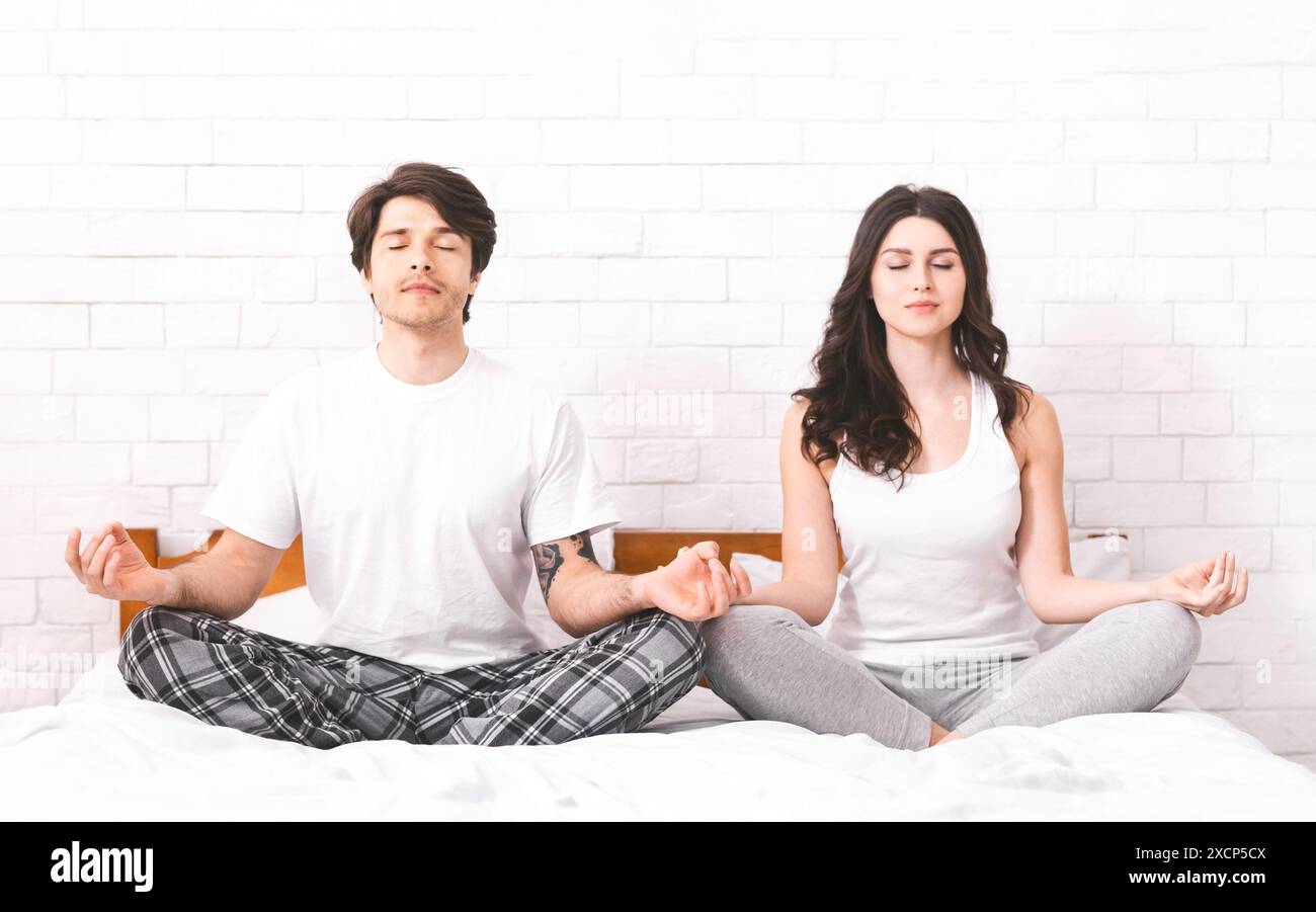 Young Couple Practicing Meditation In Bed Together In The Morning Stock ...