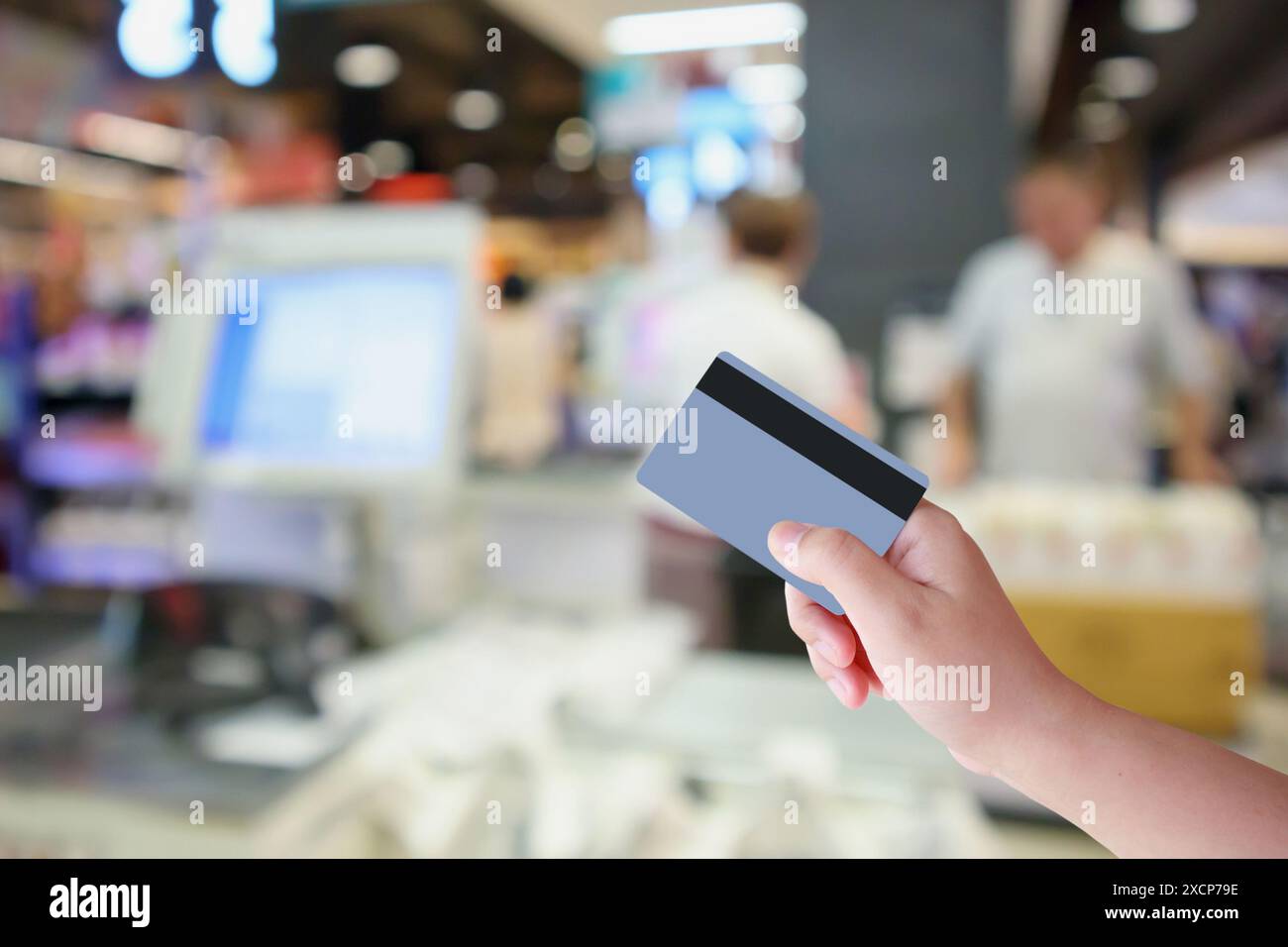 Hand hold credit card with Supermarket cashier checkout counter with ...