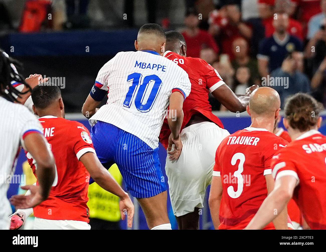 France's Kylian Mbappe hits his head on the shoulder of Austria's Kevin ...