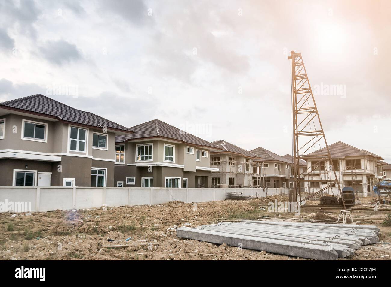 house building at construction site with pile driver and precast ...