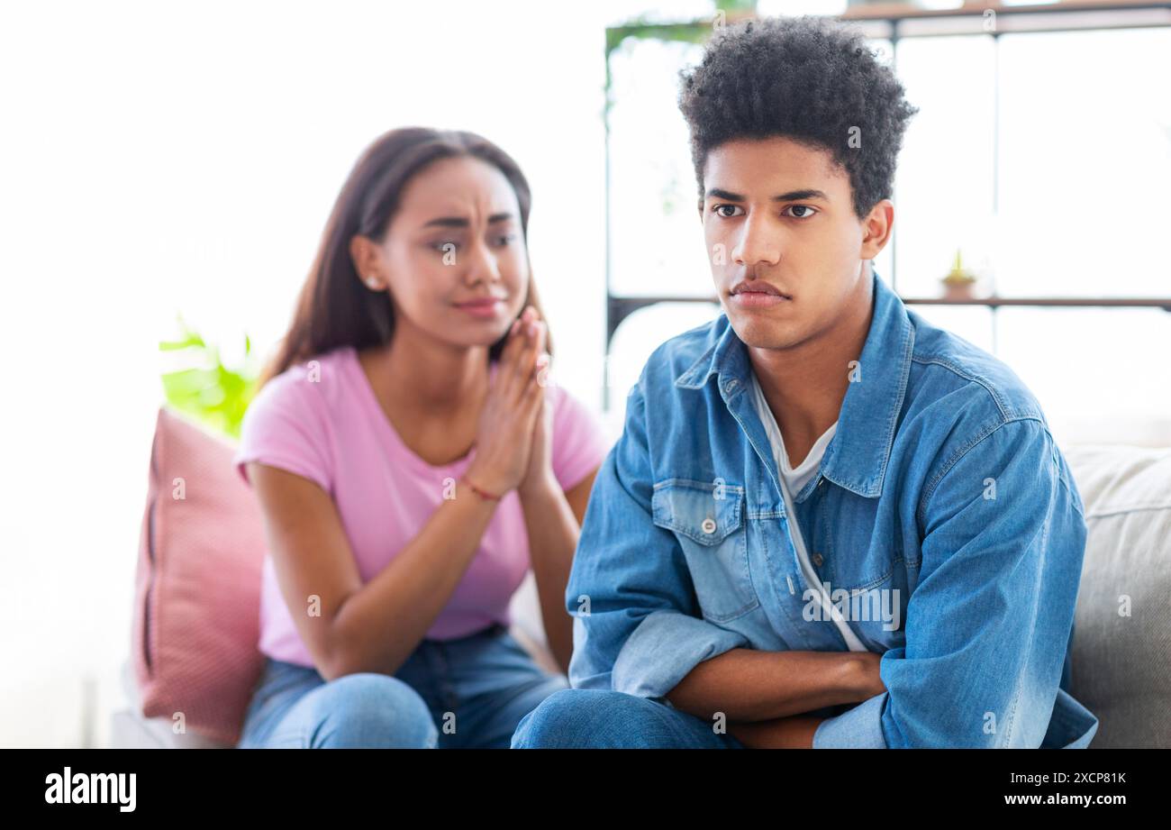 Teen Guy Sitting On Couch While Girl Apologizes To Him Stock Photo - Alamy
