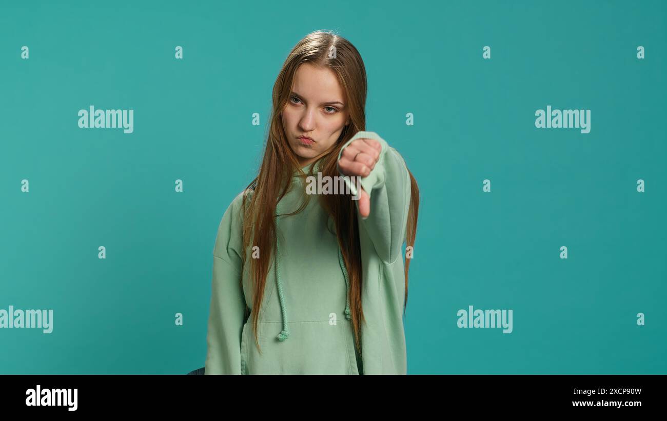 Frustrated woman showing thumbs down sign gesturing, disapproving and ...