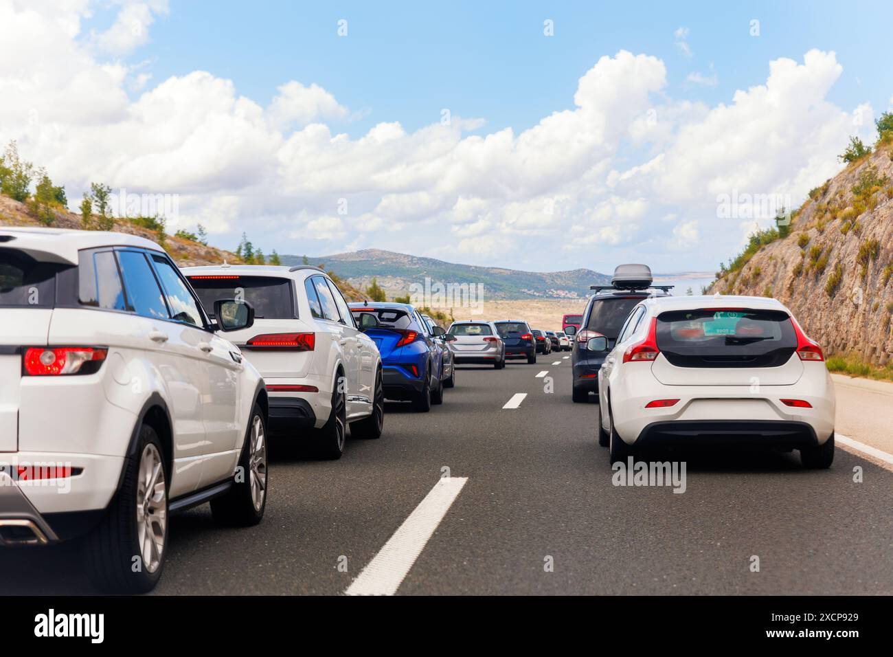 Back tail view of many cars stuck in row at highway road traffic jam ...