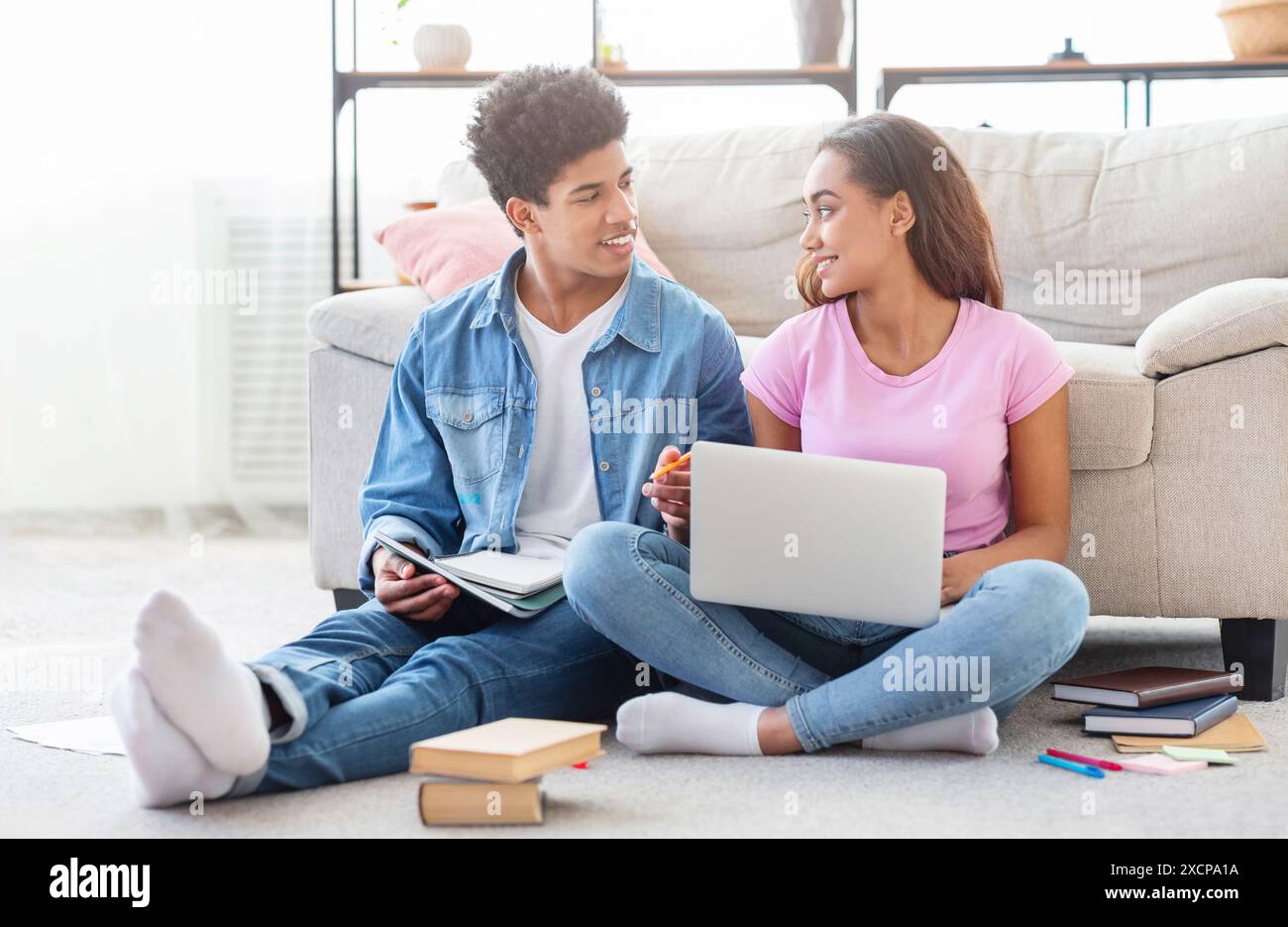 Teen Couple Studying Together at Home With Laptop and Books Stock Photo ...