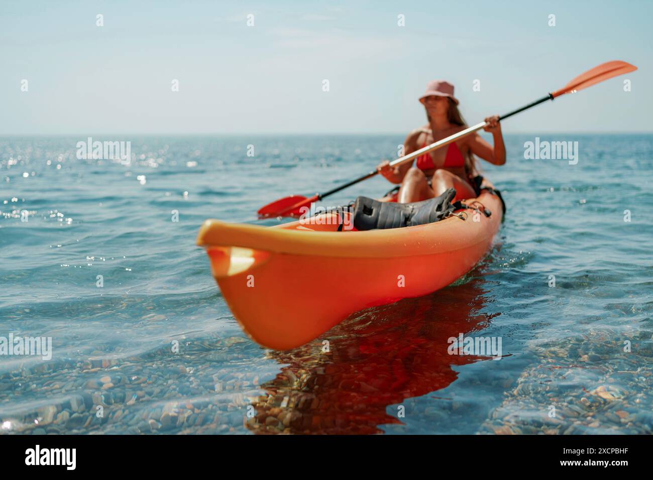 Kayak sea woman. Happy attractive woman with long hair in red swimsuit ...