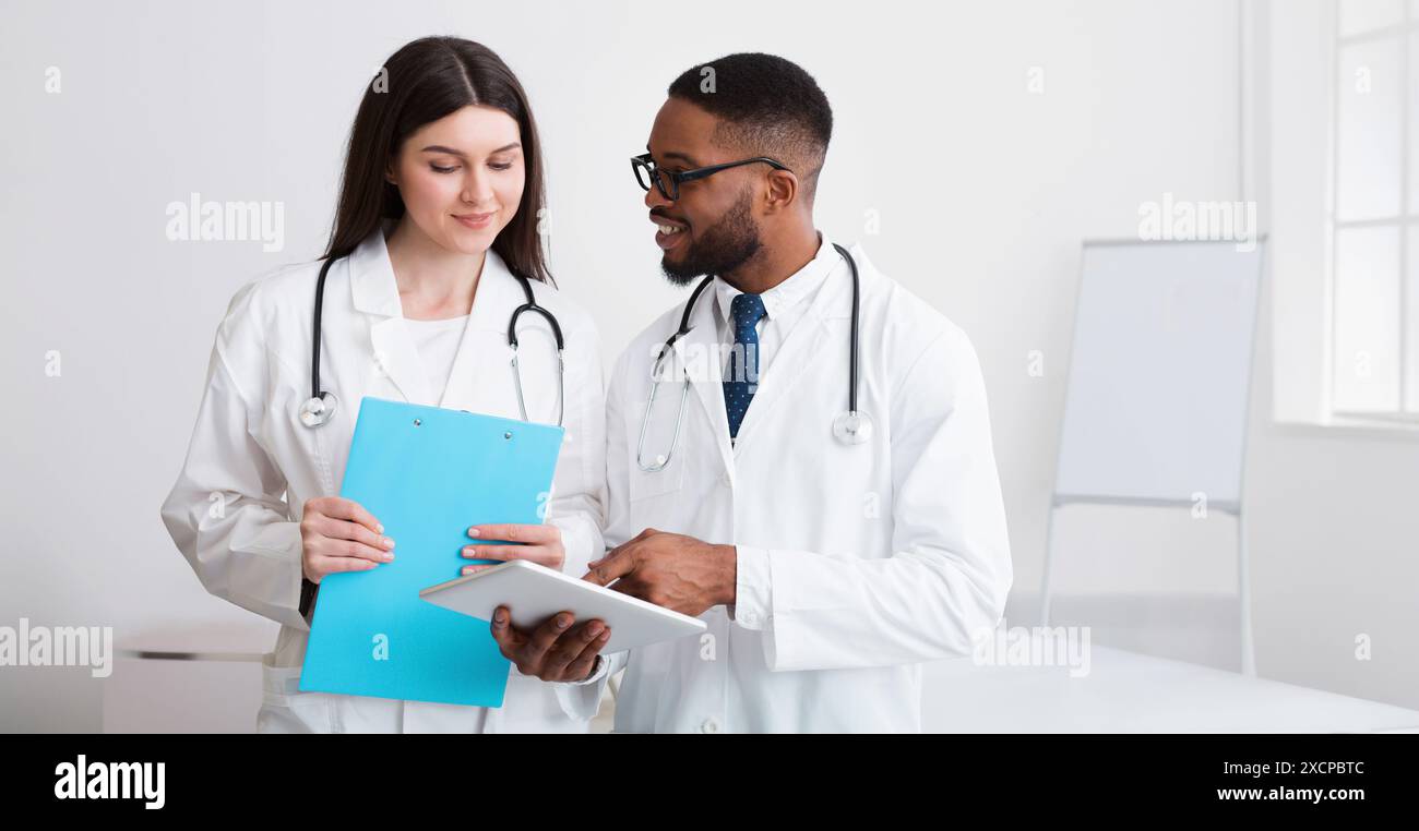 Discussing Diagnosis. Diverse Doctors Using Digital Tablet Stock Photo ...