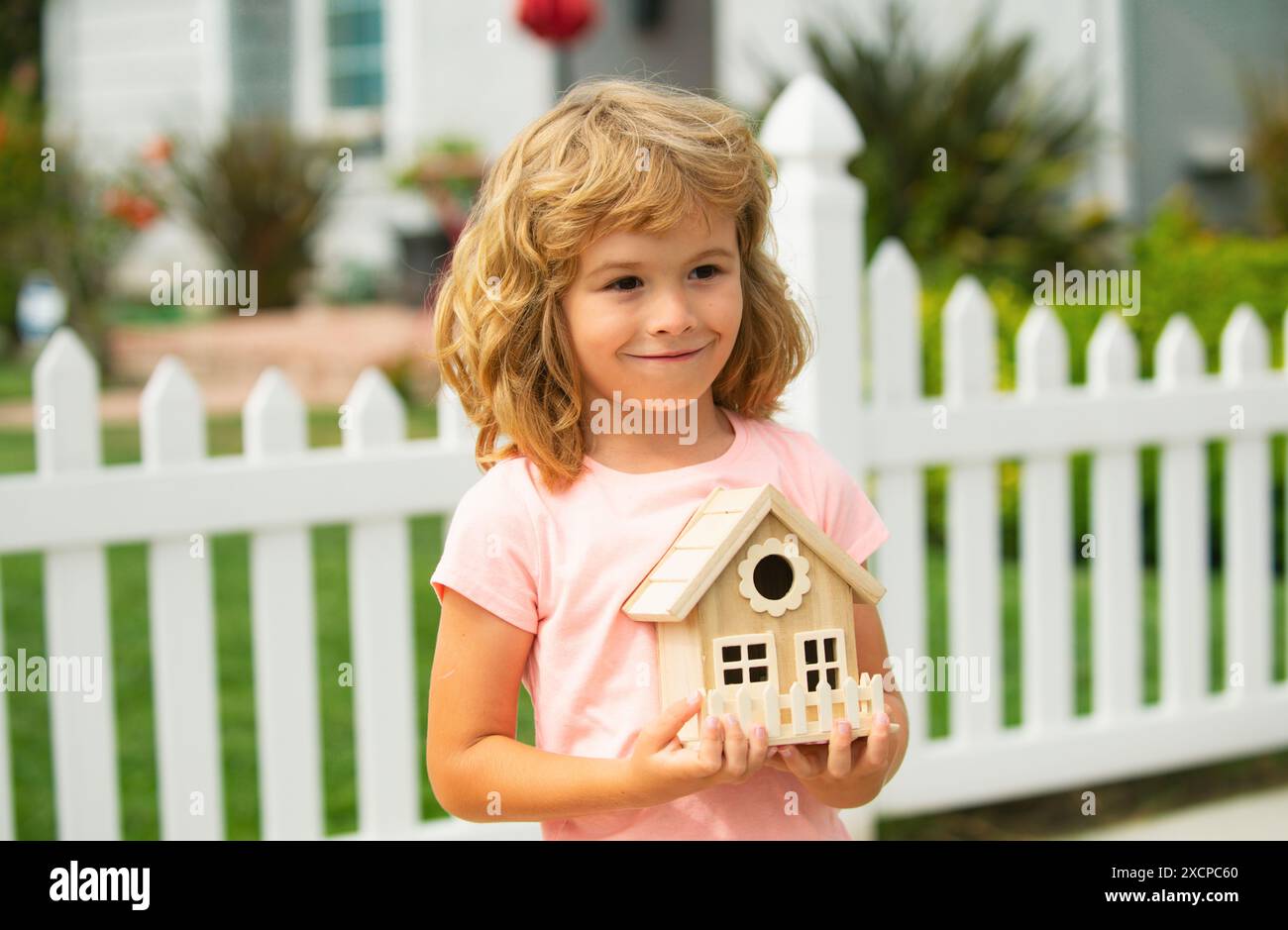 Kid dreaming of new home. Happy boy holding dream house in their hands ...