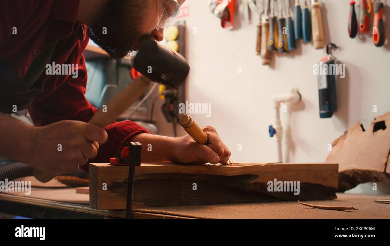 Artisan using bench vise to hold timber block, carving intricate ...