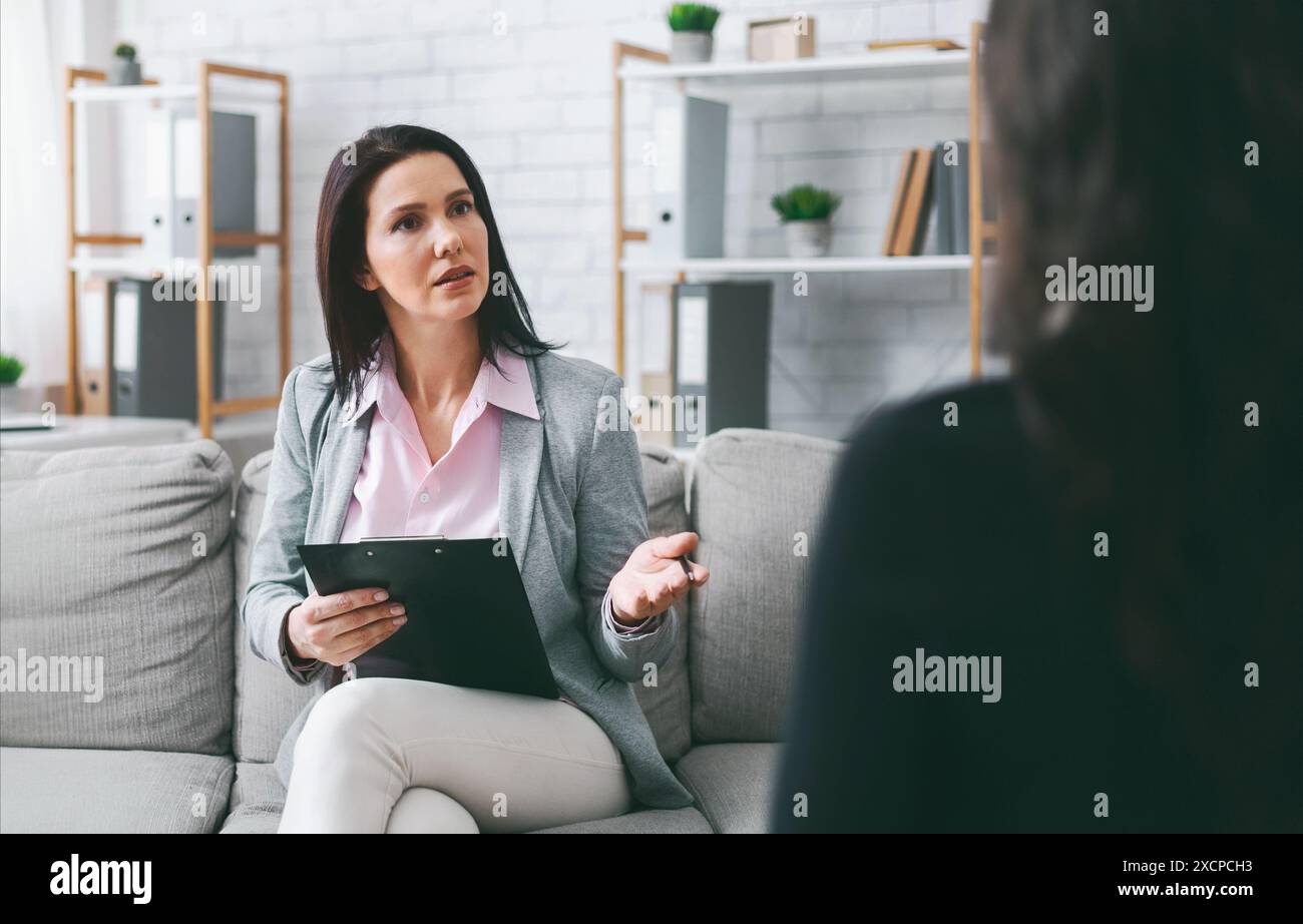 Woman Therapist Talking To Patient In Office Setting During Therapy ...