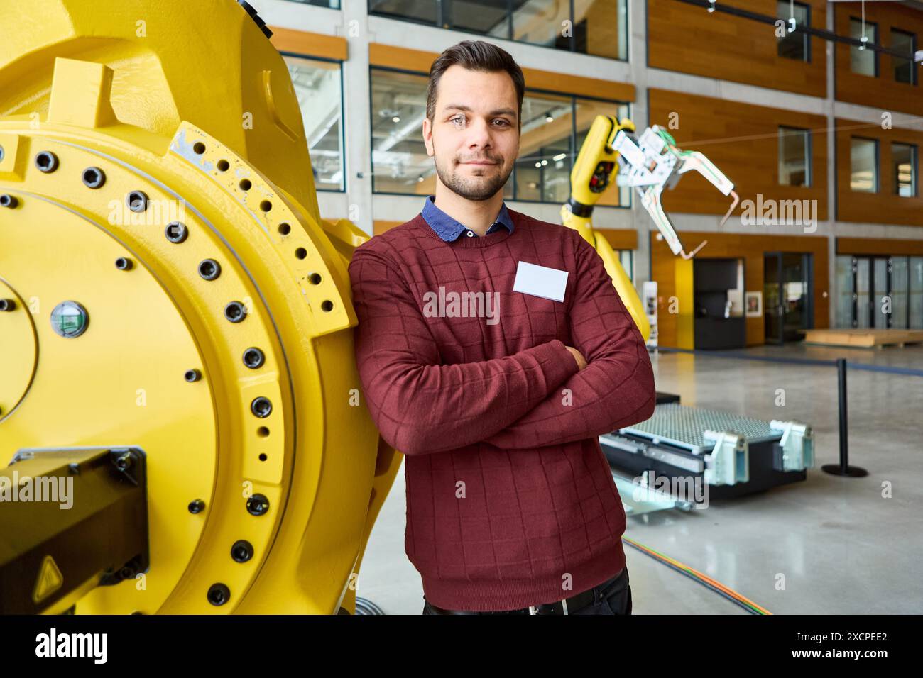 Confident engineer with crossed arms standing beside advanced ...