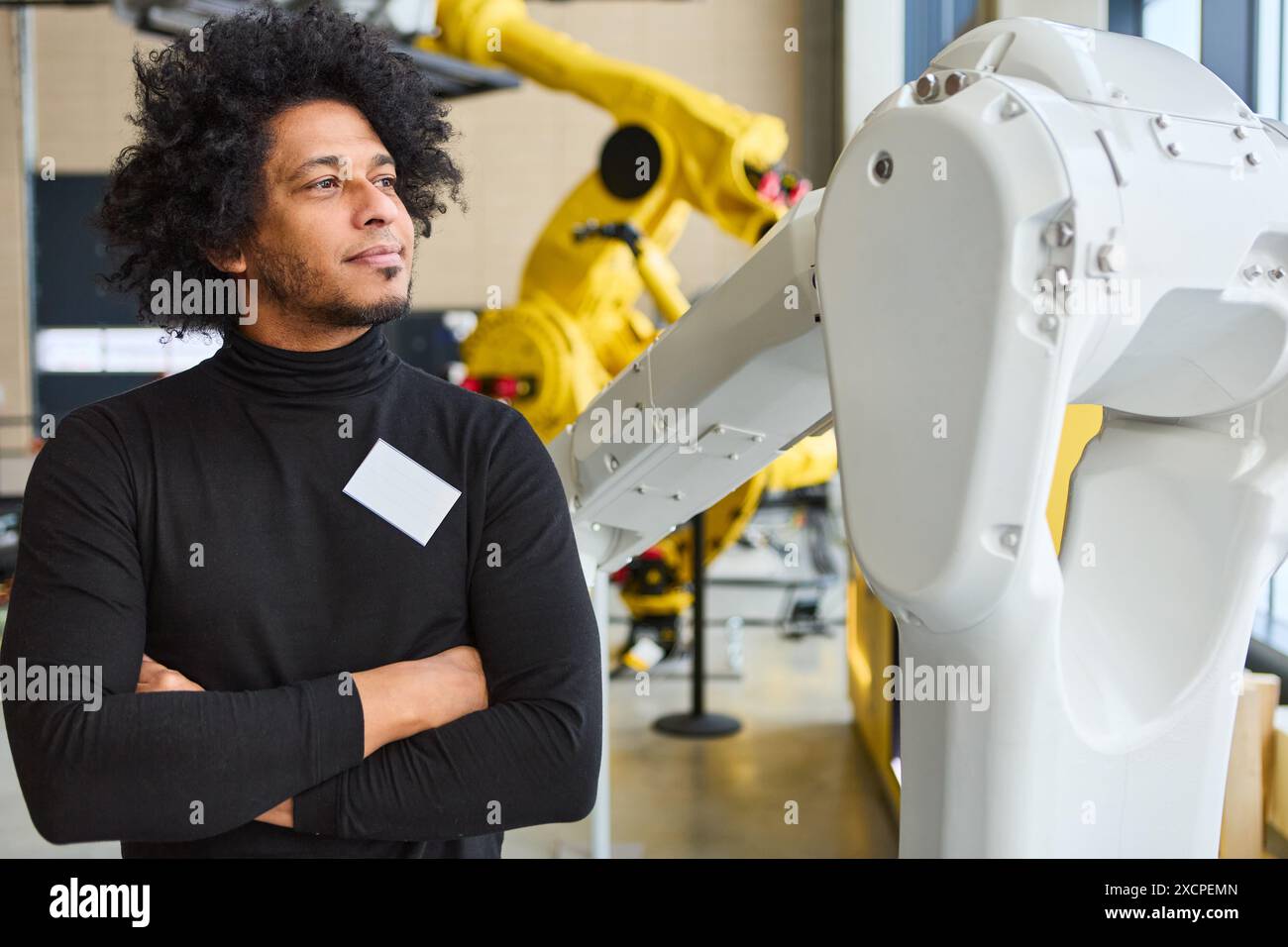 Engineer attentively observing a robotic arm in a contemporary ...