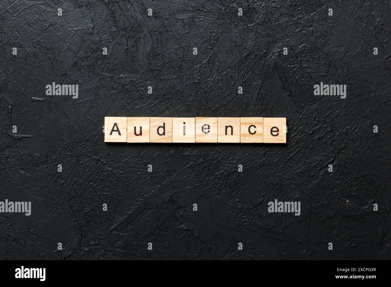 AUDIENCE word written on wood block. AUDIENCE text on cement table for ...