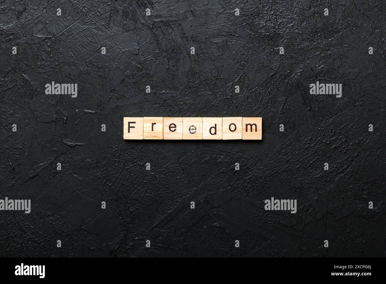 Freedom word written on wood block. Freedom text on cement table for ...