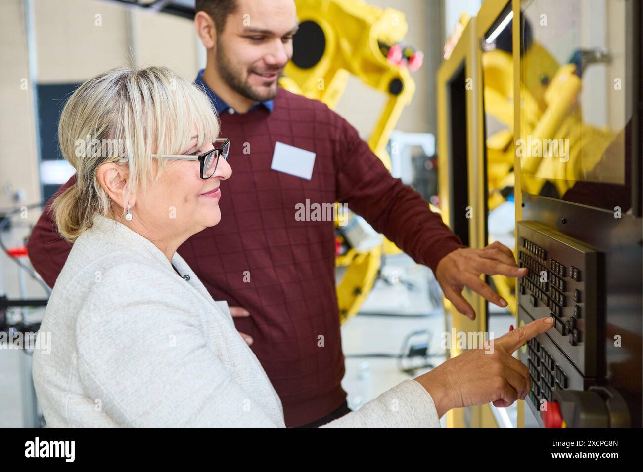 Engineers programming a robotic arm for industrial automation. Focus on training and development ...
