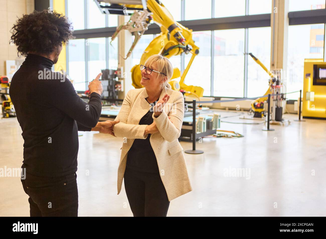 Two engineers engaging in conversation about robotics innovations in a ...